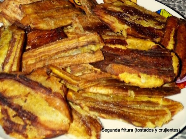 Plátano macho verde frito (tostón, patacón) con carne picada y pollo.